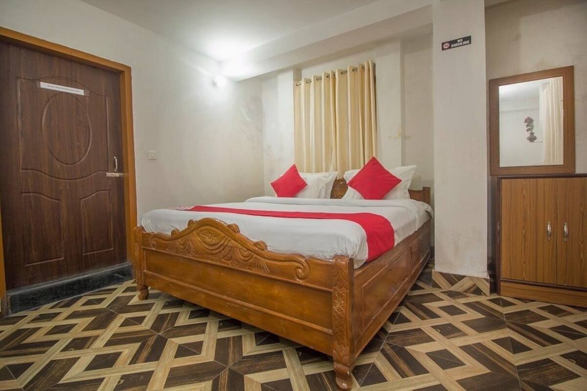 Quarto com cama de madeira, guarda-roupa e uma porta.