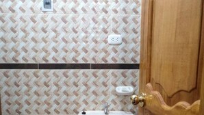 Um banheiro pequeno com vaso sanitário, pia e porta de madeira.