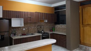 Uma cozinha com armários de madeira, fogão a gás e uma pia.