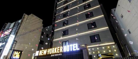 Um hotel de vários andares com um letreiro chamativo que diz 'New Yorker Hotel'.