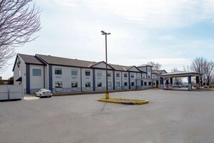 Hotel com vários andares, estacionamento e área externa coberta.