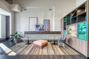 Uma área de estar moderna com um sofá, duas mesinhas e uma mesa de centro.