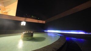 Uma área de piscina com um recurso aquático e um aparelho de iluminação.