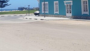 Um edifício de dois andares com um telhado íngreme e uma varanda no segundo pavimento.