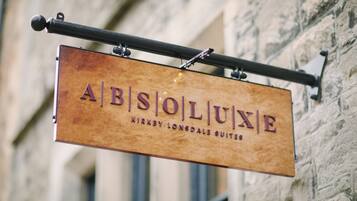 Placa do hotel 'ABISOLUXE', indicando que se trata das Suítes Kirkby Lonsdale.