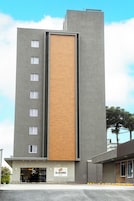 Um edifício moderno com um painel vertical central de madeira, várias janelas e uma placa com a inscrição 'SLAVIERO slim' na entrada.