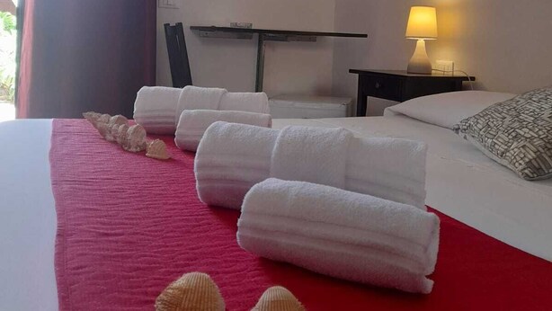 Quarto de hotel com cama, mesa de cabeceira, abajur e vista para o exterior.