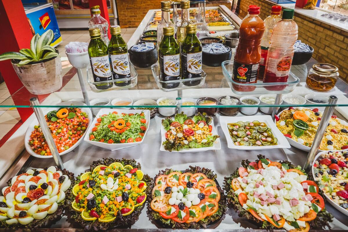 Um buffet com diversas saladas, patês e acompanhamentos.
