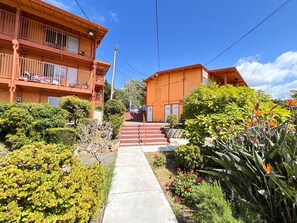 Um edifício de vários andares com um caminho de concreto que leva à entrada.