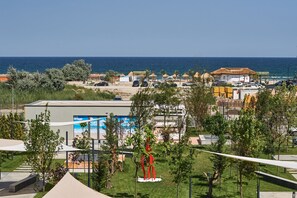 Hotel à beira-mar com vista para o mar, área de estar externa e um edifício moderno com placa azul.