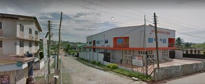 Um edifício de dois andares com uma placa indicando 'Mace Lodge' e uma entrada visível.