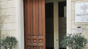 Uma porta de madeira com design moderno, acompanhada por dois vasos de plantas.