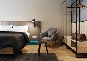 Quarto moderno com cama, mesa de cabeceira, cadeira e guarda-roupa com espaço para pendurar roupas.