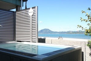 Banheira de hidromassagem com vista para o mar e montanhas.
