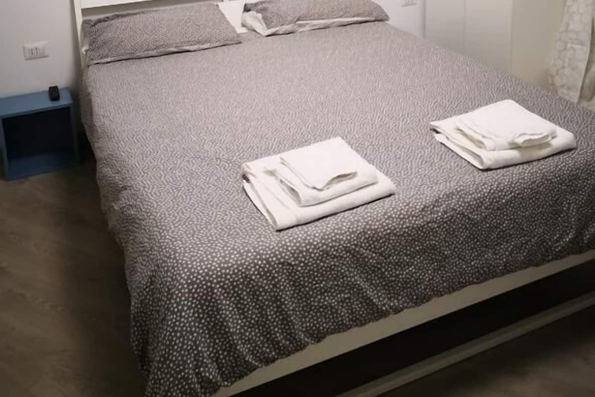 Quarto com cama, guarda-roupa, um quadro e ar condicionado.