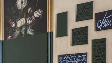 Paredes decoradas com diversos quadros e trabalhos de caligrafia.