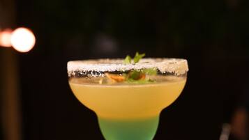 Um cocktail num copo de martini com borda salgada sobre uma mesa.
