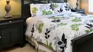 Quarto com cama, duas mesas de cabeceira e duas luminárias.