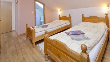 Quarto com duas camas de madeira, um guarda-roupa de madeira e um espelho.