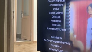 Televisão exibindo uma lista de peças musicais e os detalhes da gravação.
