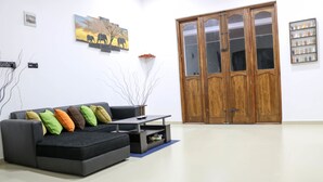 Uma sala de estar moderna com um sofá seccional, uma mesa de centro e um guarda-roupa de madeira.