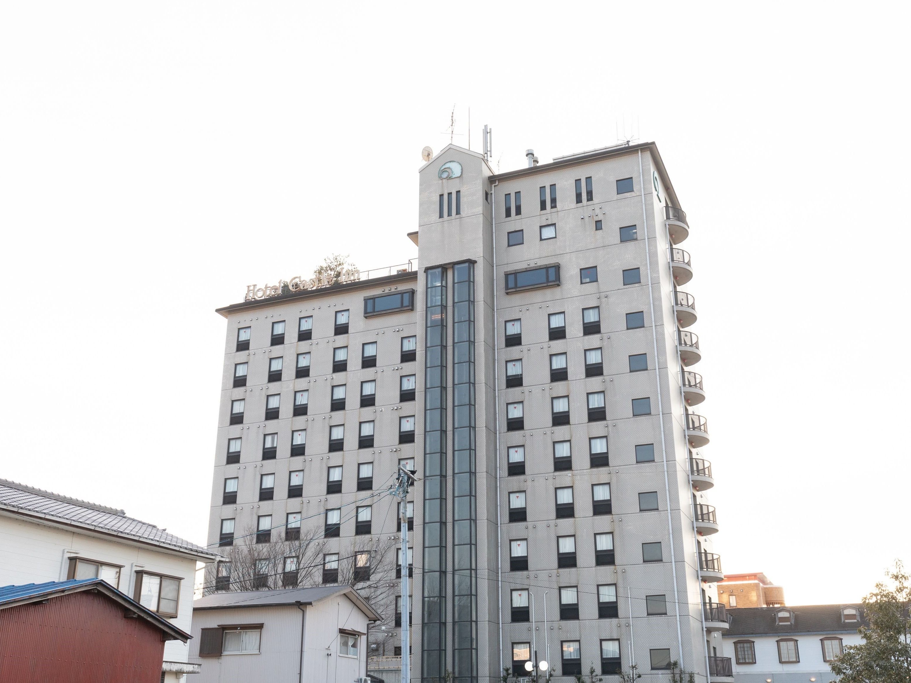 Um hotel moderno e alto, com vários andares, janelas amplas e uma antena proeminente no telhado.