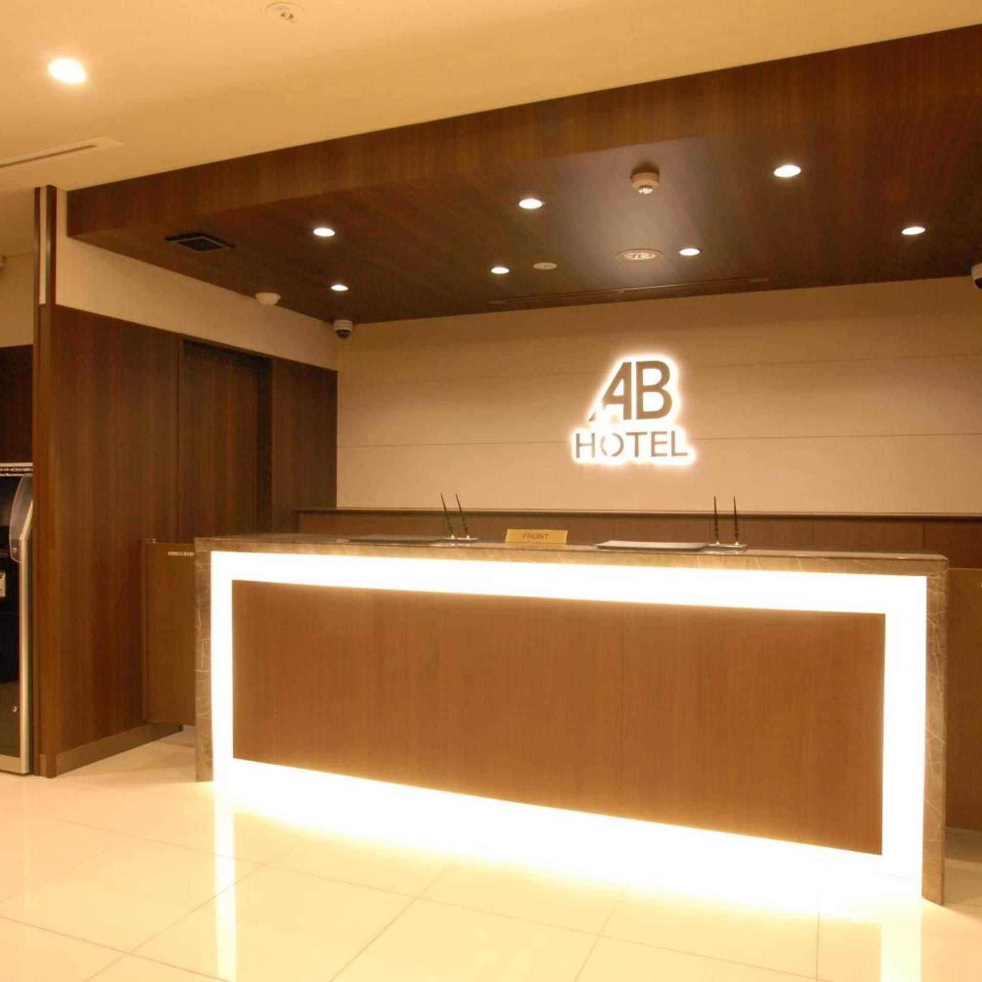 Balcão de recepção de hotel com uma placa que diz 'AB HOTEL'.