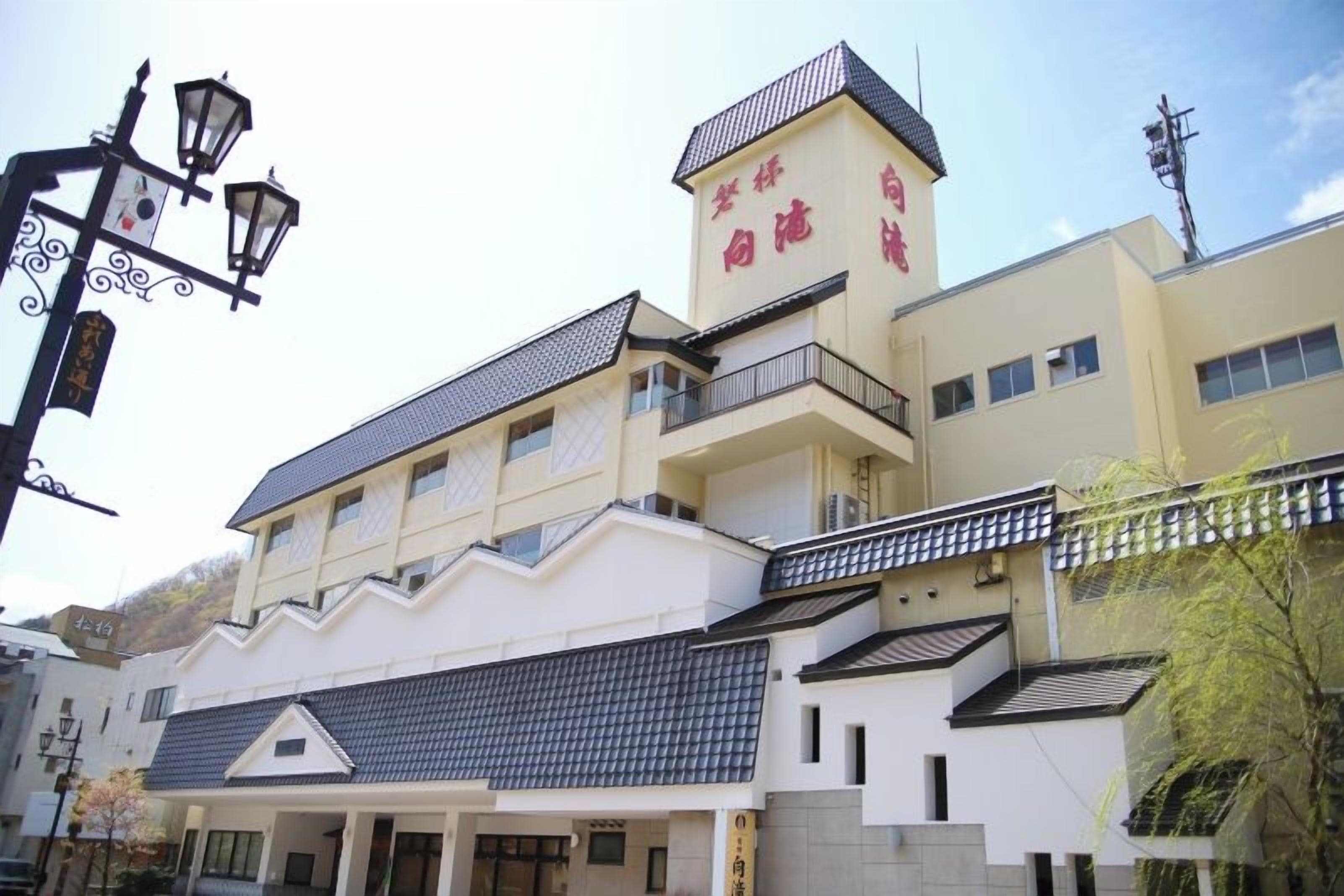 Um edifício de vários andares com telhado plano e uma pequena estrutura semelhante a uma torre no topo.