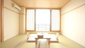 Um quarto japonês tradicional com tatames, uma mesa baixa e portas deslizantes shoji.