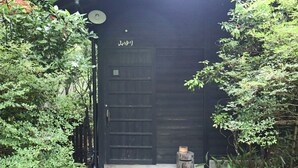 Uma porta de madeira escura com uma pequena janela e uma placa em cima.