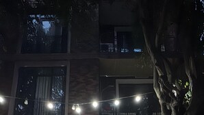 Um hotel chamado "HOTEL ELITE", com fachada de tijolos, área de estar ao ar livre e entrada visível.