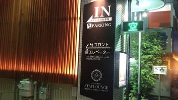 Entrada de hotel com placa indicando área de estacionamento.