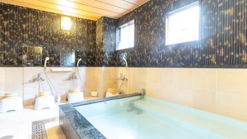 Um polibã e uma banheira separados, um secador de cabelo, um bidé