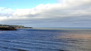 Paisagem costeira com vista para o mar e uma orla rochosa.