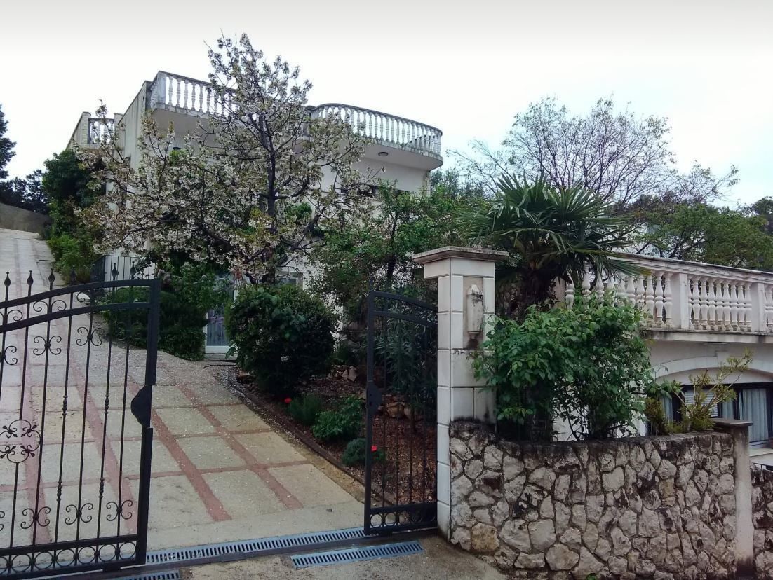 Uma entrada protegida por um muro de pedra e um portão de metal.