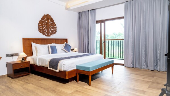 Quarto moderno com cama de madeira, um banco, mesa de cabeceira e uma janela grande com cortinas.
