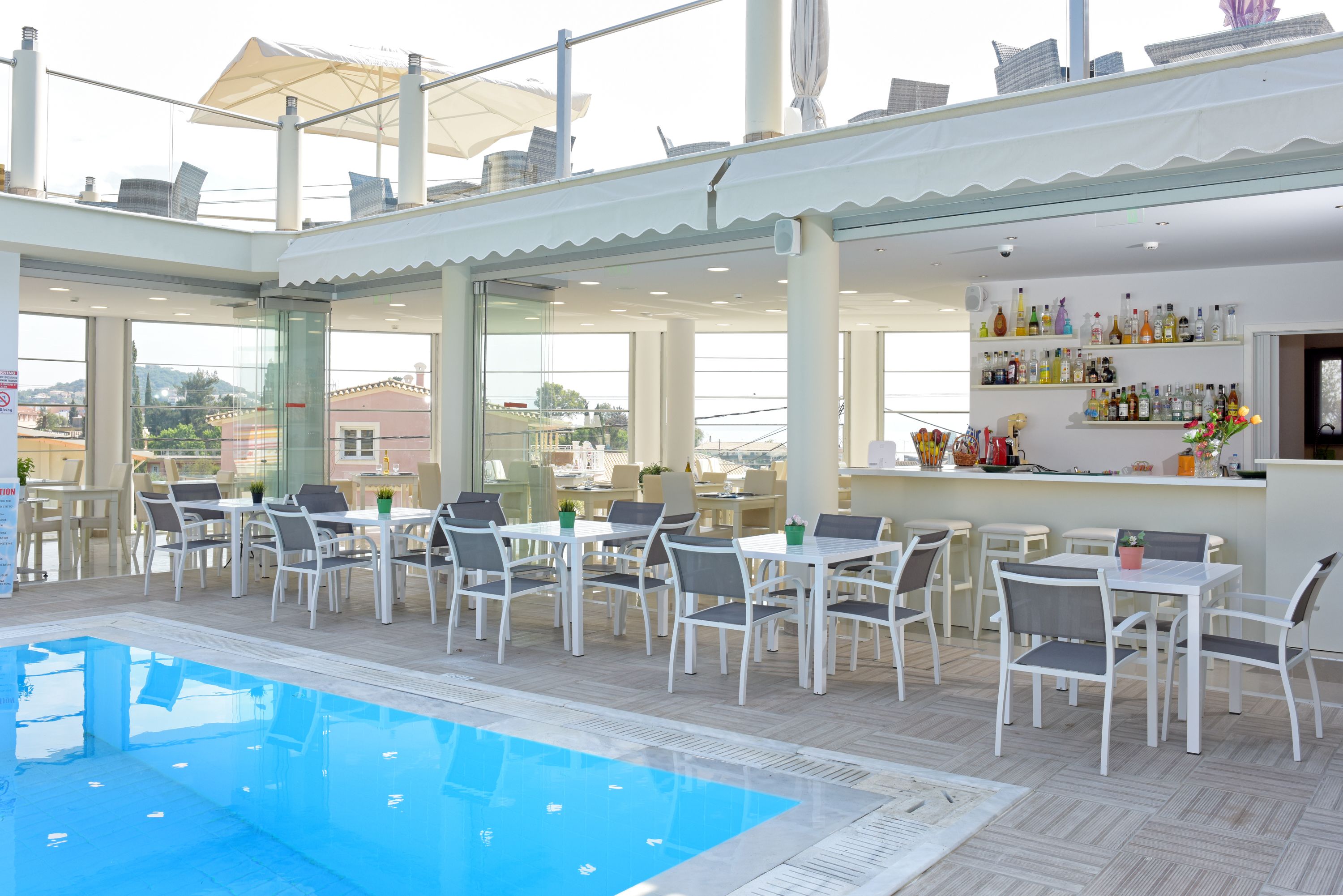 Uma área ao lado da piscina com assentos externos e um bar.
