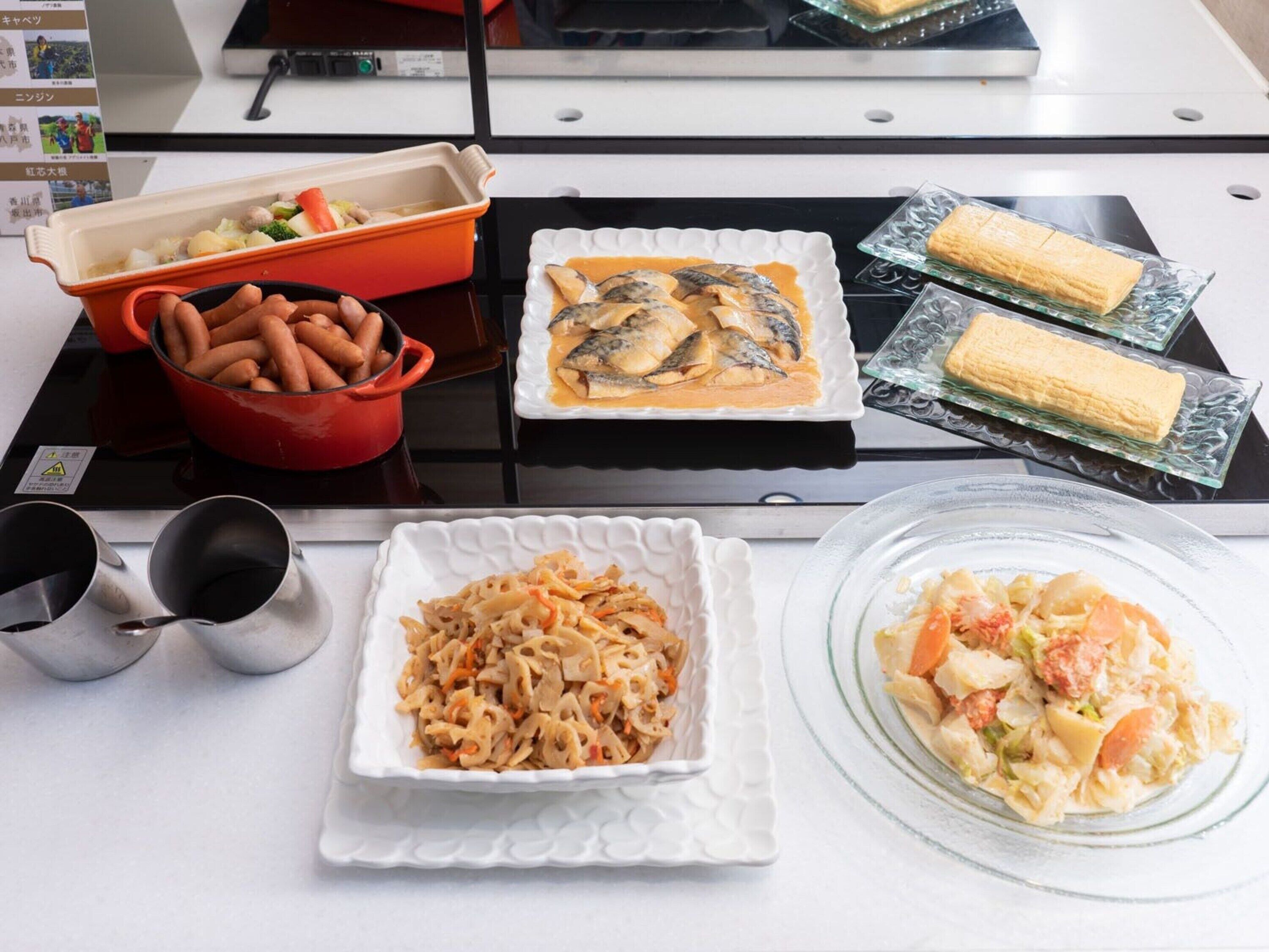 Uma bancada de cozinha com diversos pratos, incluindo peixe, massa e pão.