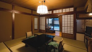 Um quarto japonês tradicional com tatames, uma mesa baixa e portas corrediças.