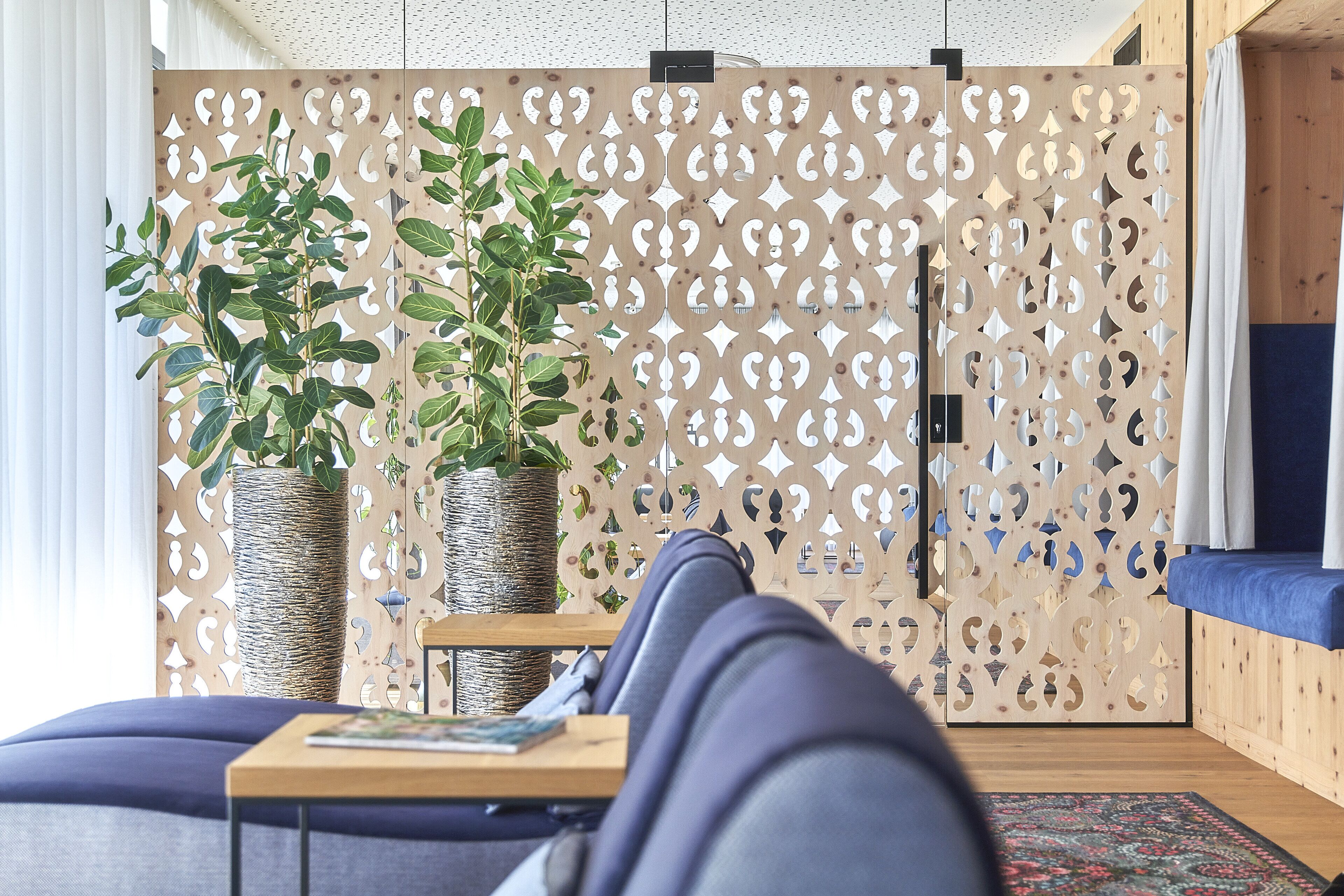 Uma sala de estar moderna com um sofá, uma mesa de centro e plantas decorativas.