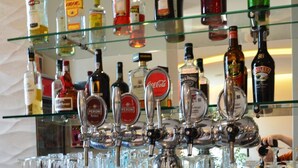 Uma área de bar com várias garrafas de bebidas e um sistema de torneiras.