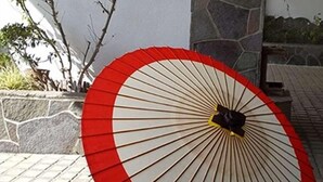 Um sinal com caracteres japoneses e um guarda-chuva vermelho e branco.