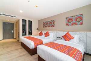 Quarto de hotel com duas camas, cabeceira de mármore e design de parede estampado.