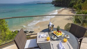 Varanda com mesa posta para o café da manhã com vista para a praia.