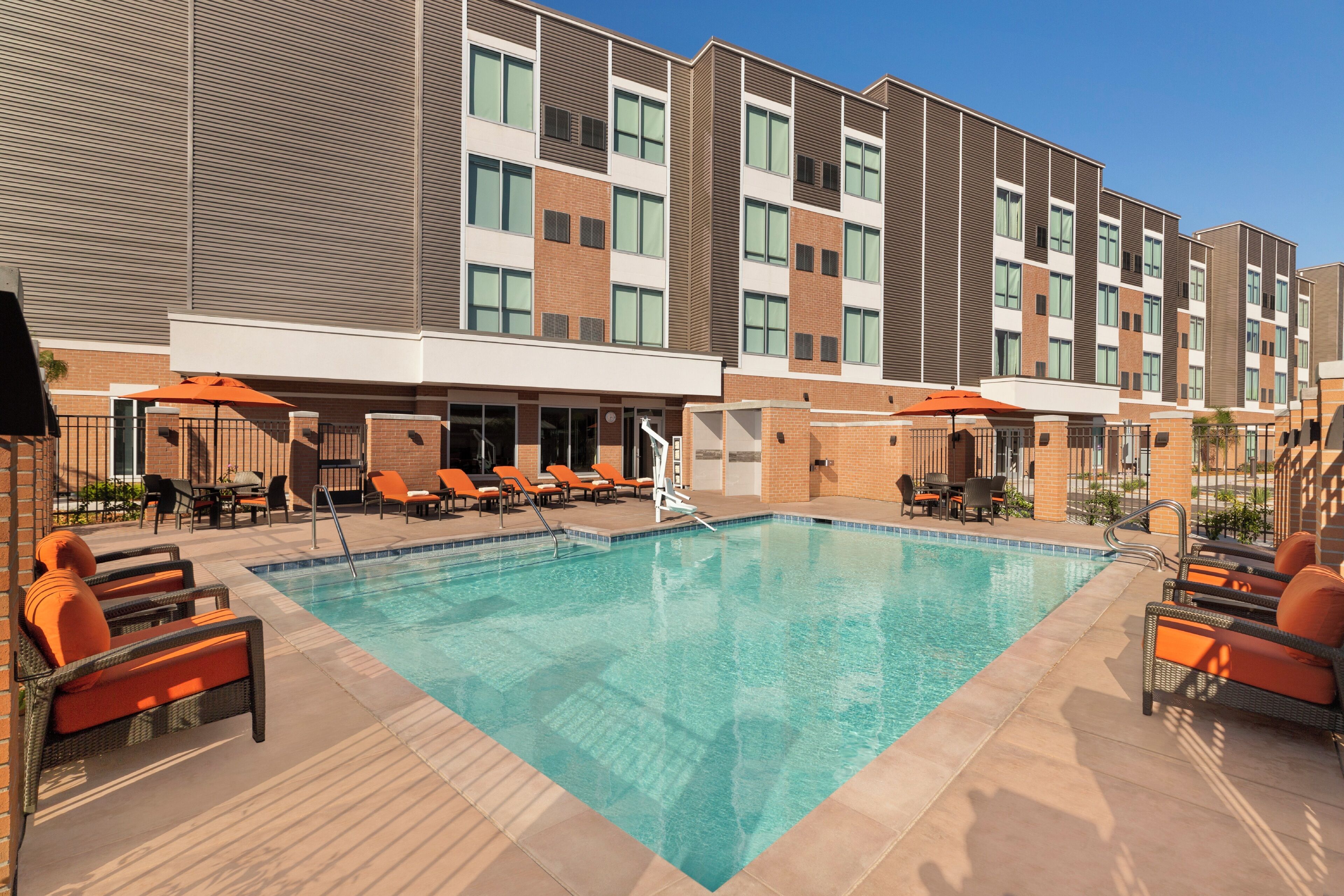 Um hotel com piscina, área de estar ao ar livre e fachada de construção moderna.