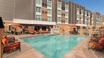 Um hotel com piscina, área de estar ao ar livre e fachada de construção moderna.
