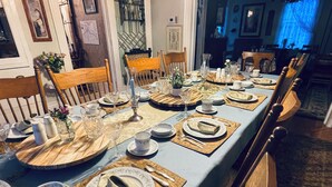 Uma mesa de jantar posta para uma refeição, com pratos, talheres e copos.