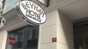 Placa de hotel com o nome 'Beiyhan Hotel' e um número de telefone.