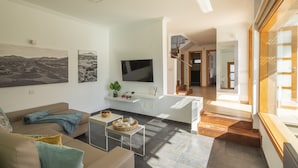 Uma sala de estar moderna com sofá, mesa de centro e obras de arte nas paredes.
