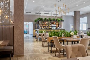 Uma área de bar moderna com diversas garrafas de bebidas, um letreiro Redling e plantas verdes.